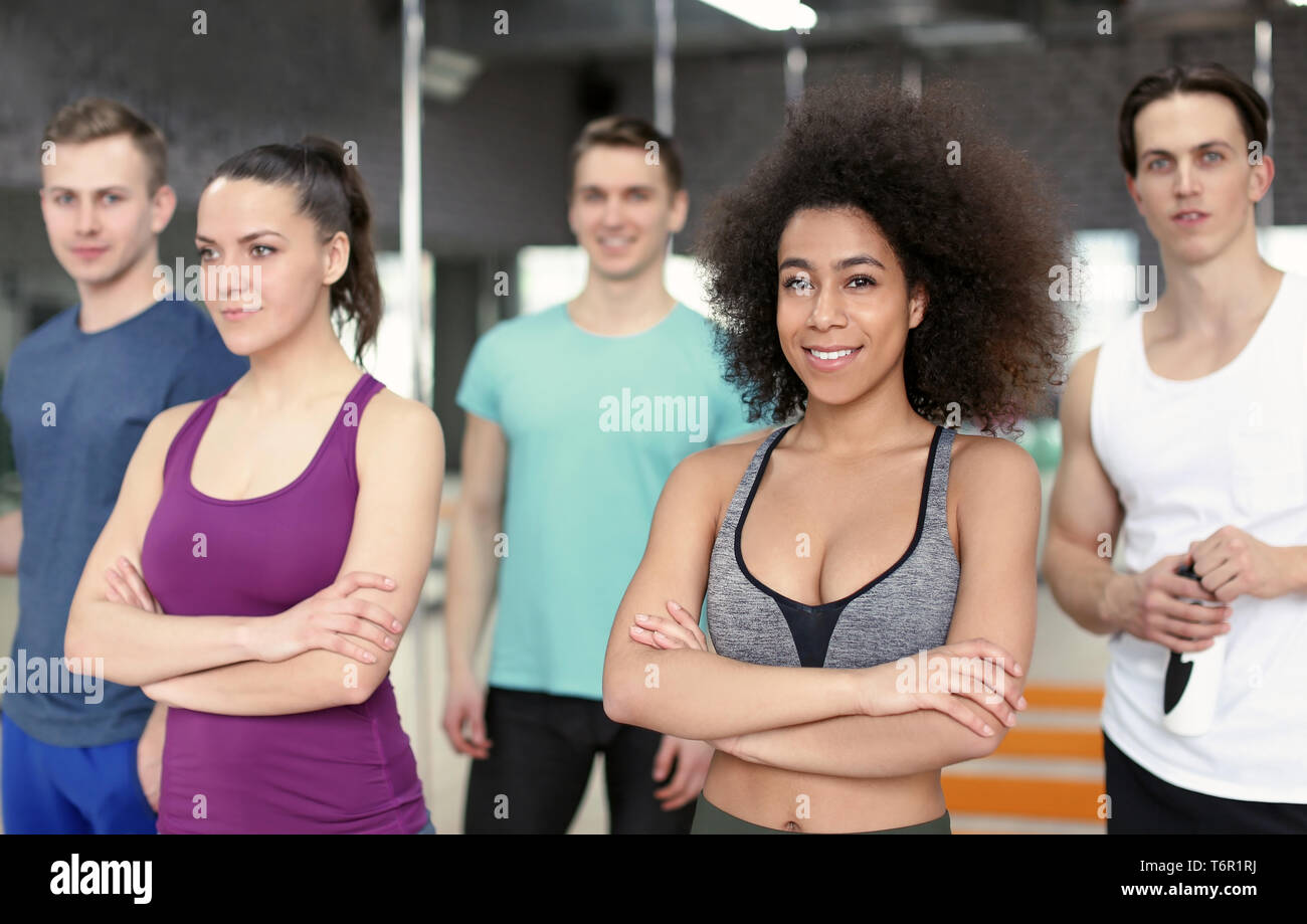 Sporty girl with group of athletes in gym Stock Photo - Alamy