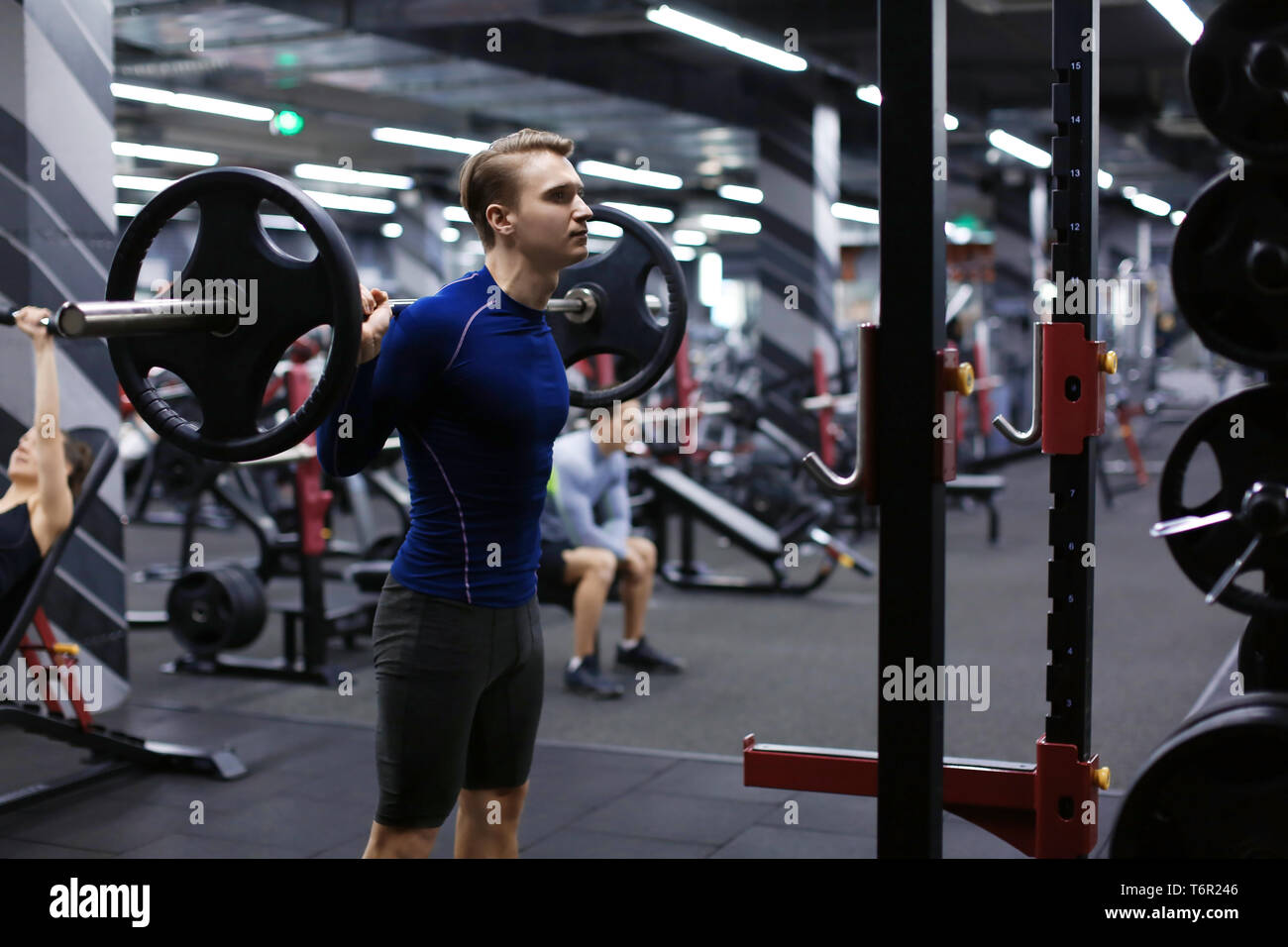 Athletic man training with barbell in modern gym Stock Photo - Alamy
