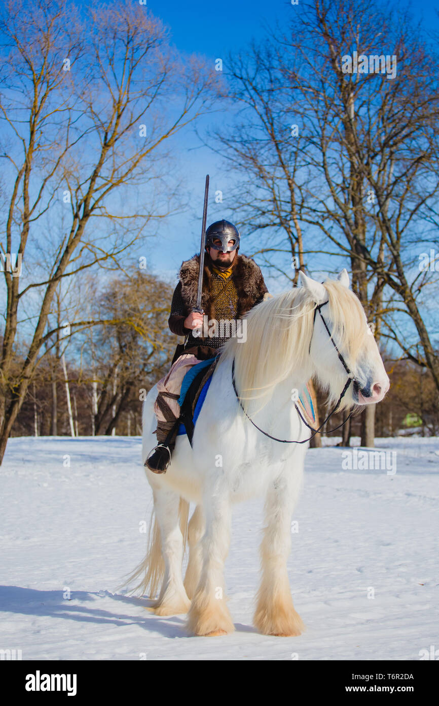 Man in suit of ancient warrior raising his sword Stock Photo - Alamy