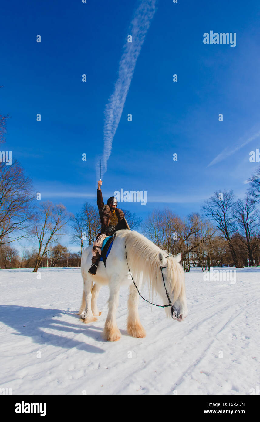 Man in suit of ancient warrior raising his sword Stock Photo - Alamy