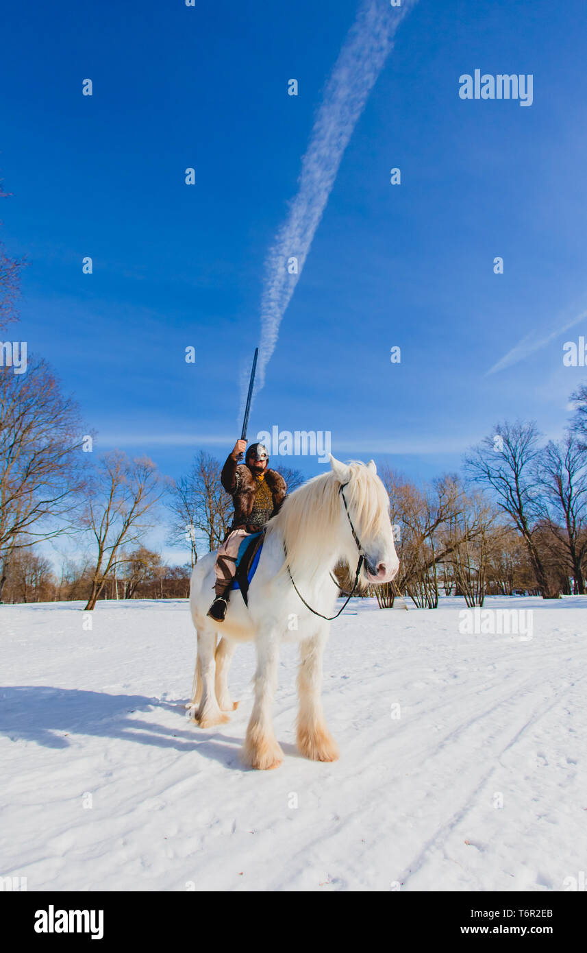 Man in suit of ancient warrior raising his sword Stock Photo - Alamy