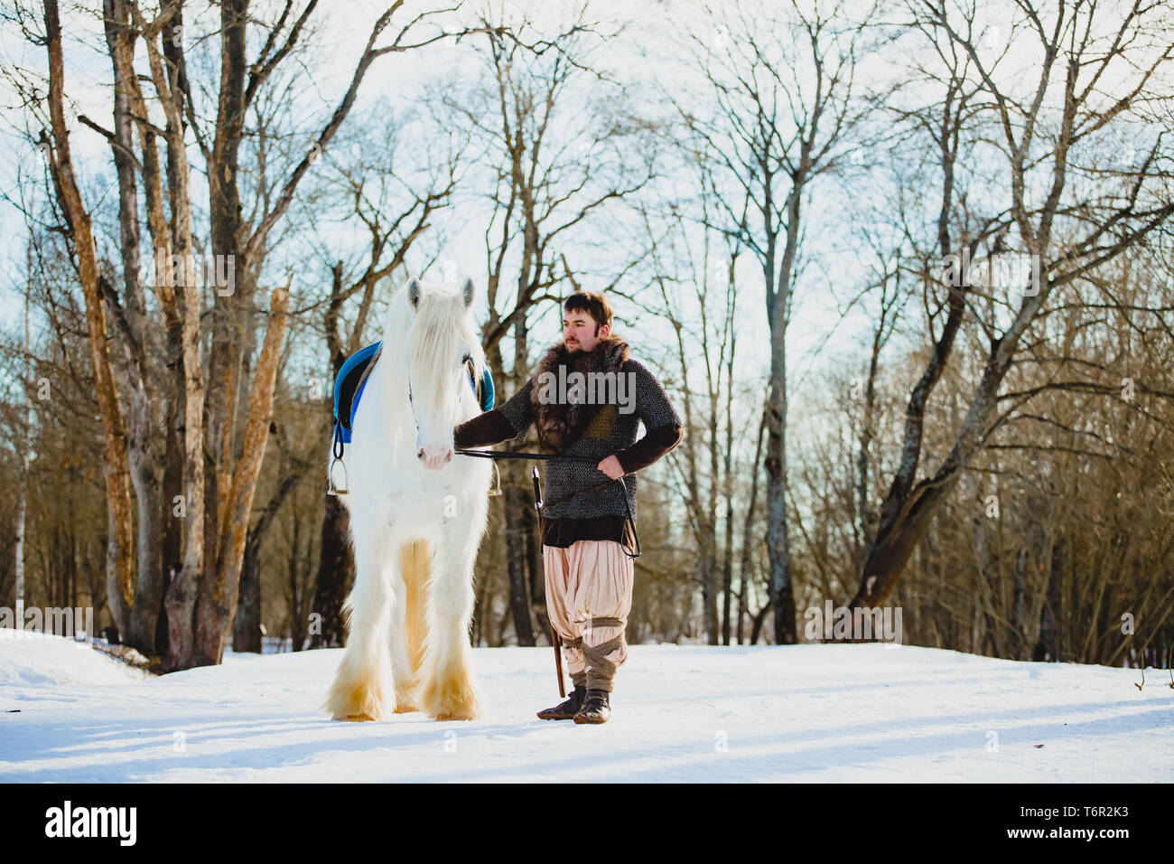 Man in suit of ancient warrior walking with the big white horse Stock ...