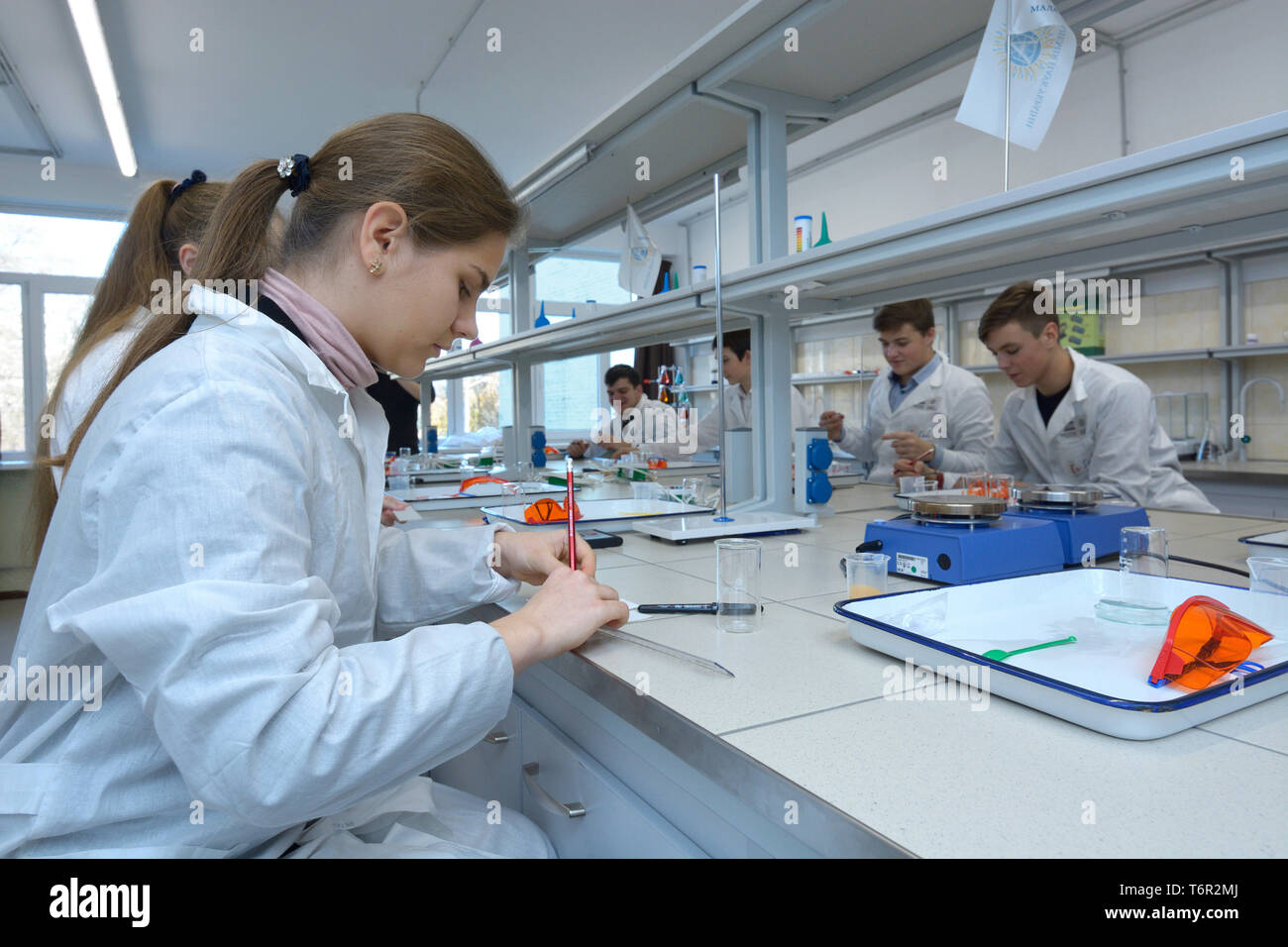 At a school chemistry lab. Female teacher conducting lesson of ...