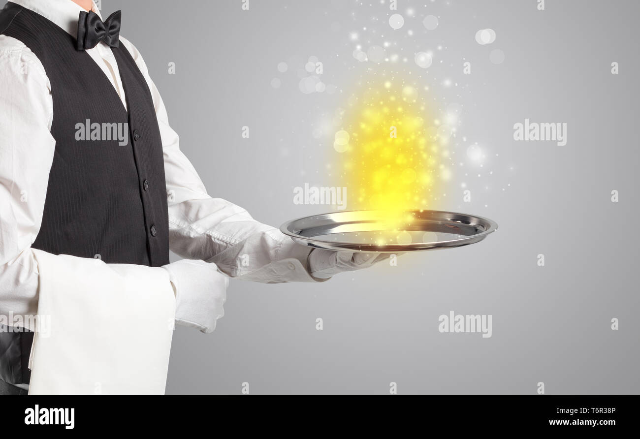Elegant young waiter serving mysterious light on tray Stock Photo - Alamy