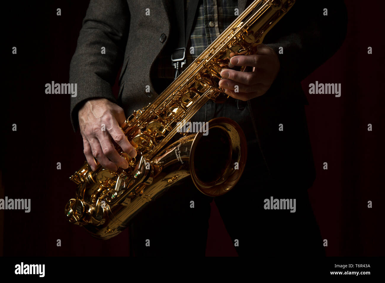Close front view of isolated sax player (torso & hands only) playing ...