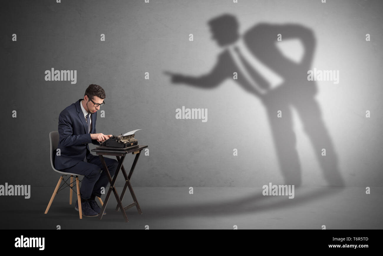 Little man working and a big shadow arguing with him Stock Photo - Alamy