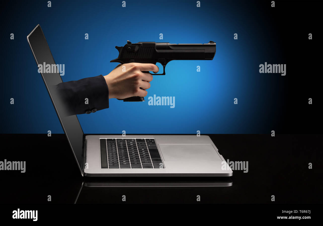Hand with gun coming out of a laptop with sparkling effects Stock Photo ...