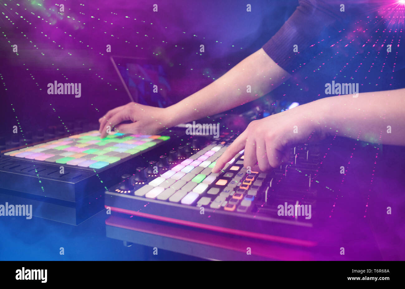 Hand mixing music on midi controller with party club colors around ...