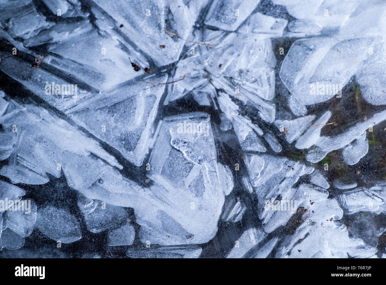 Network of cracks in thick solid frozen layer of ice with shining light ...