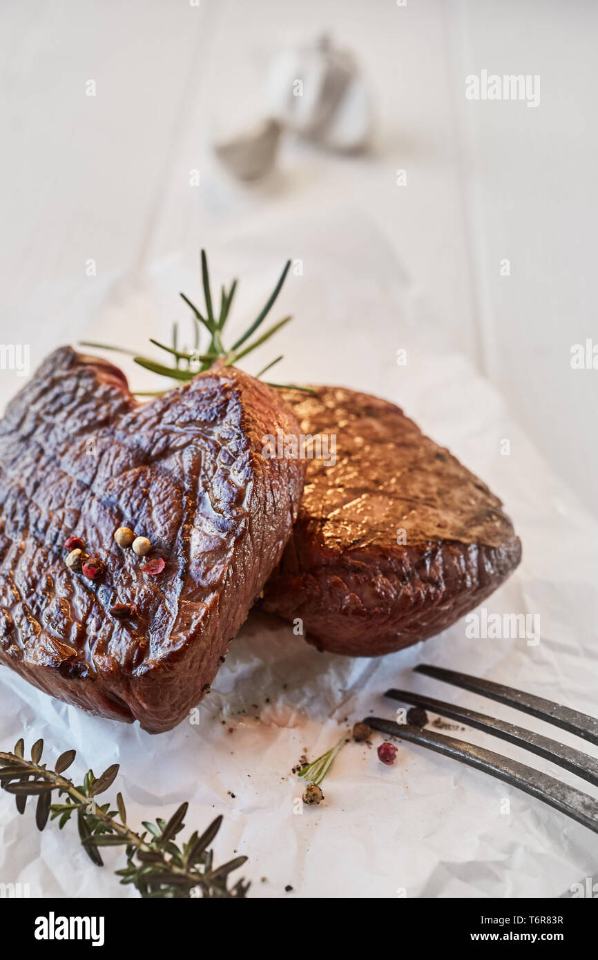 Two prime beef fillet medallions with fresh thyme and rosemary seasoned ...