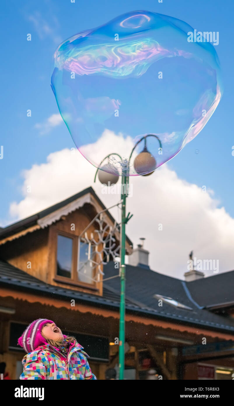 Girl looking at giant soap bubble Stock Photo - Alamy