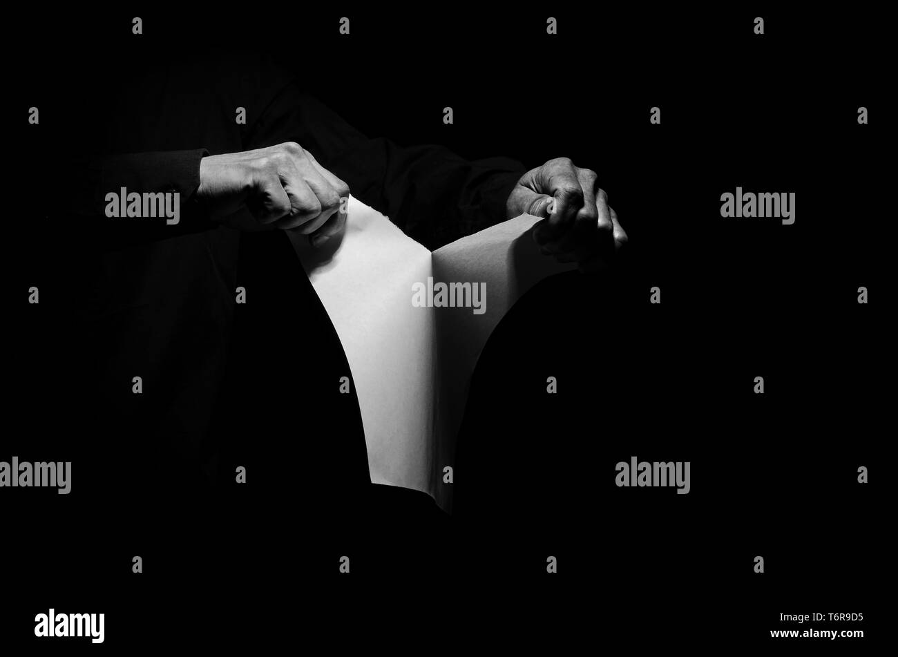 A man tearing a piece of paper in black and white Stock Photo - Alamy