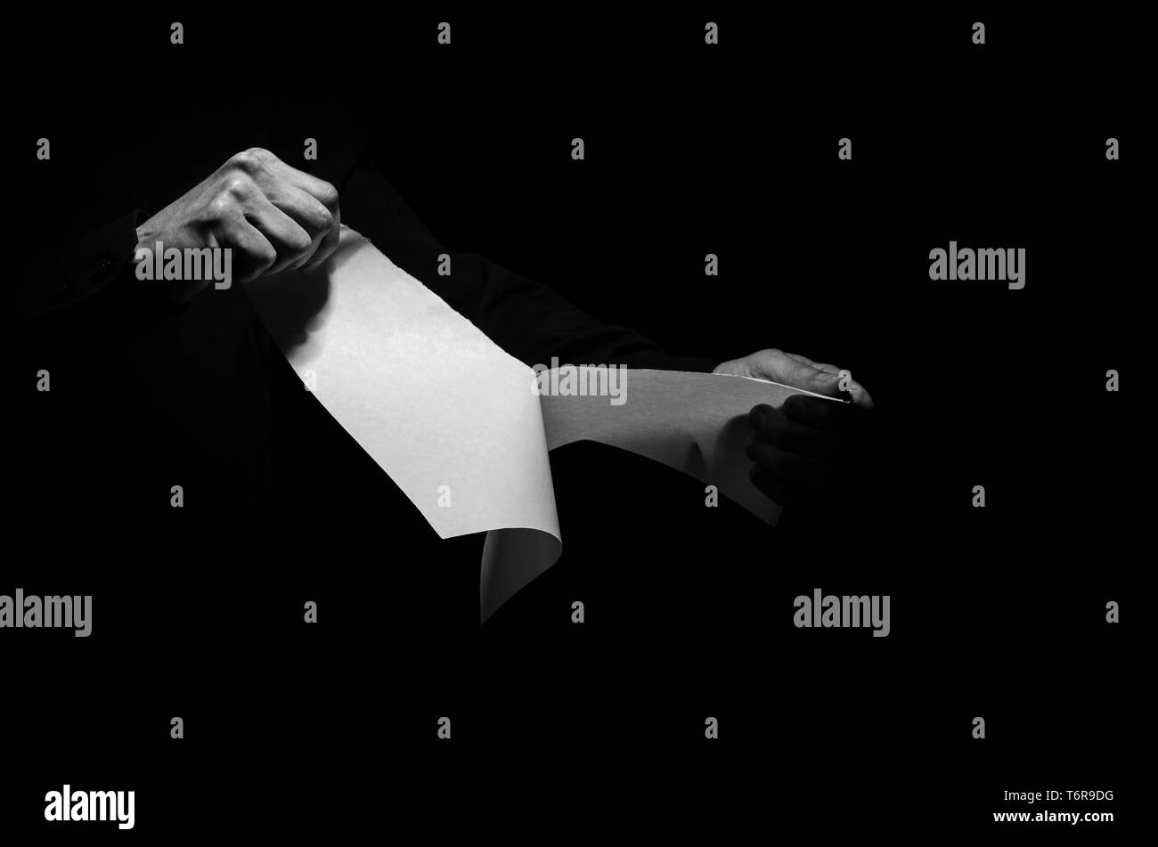 A man tearing a piece of paper in black and white Stock Photo - Alamy