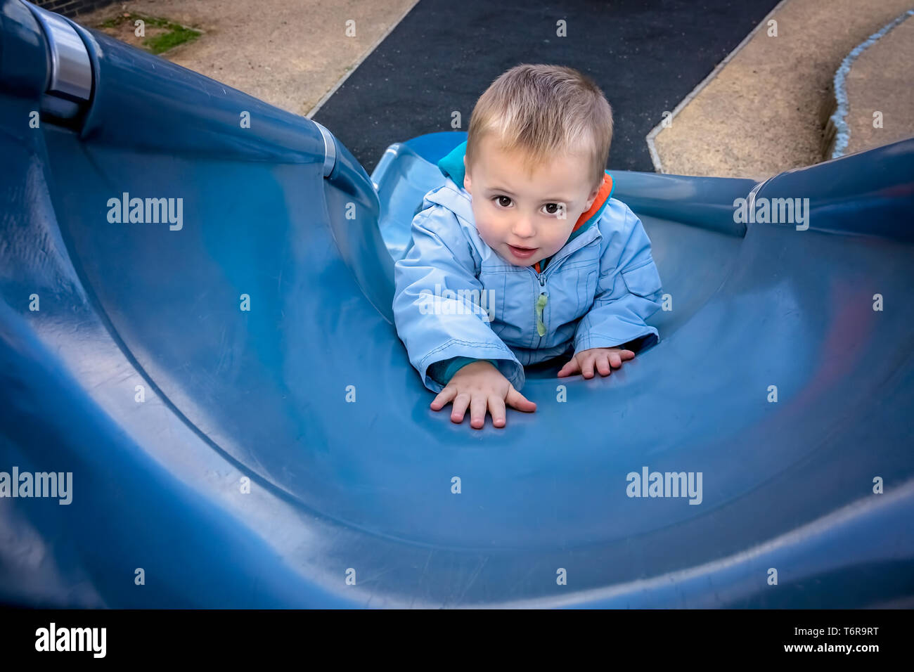Child climbing up slide hi-res stock photography and images - Alamy