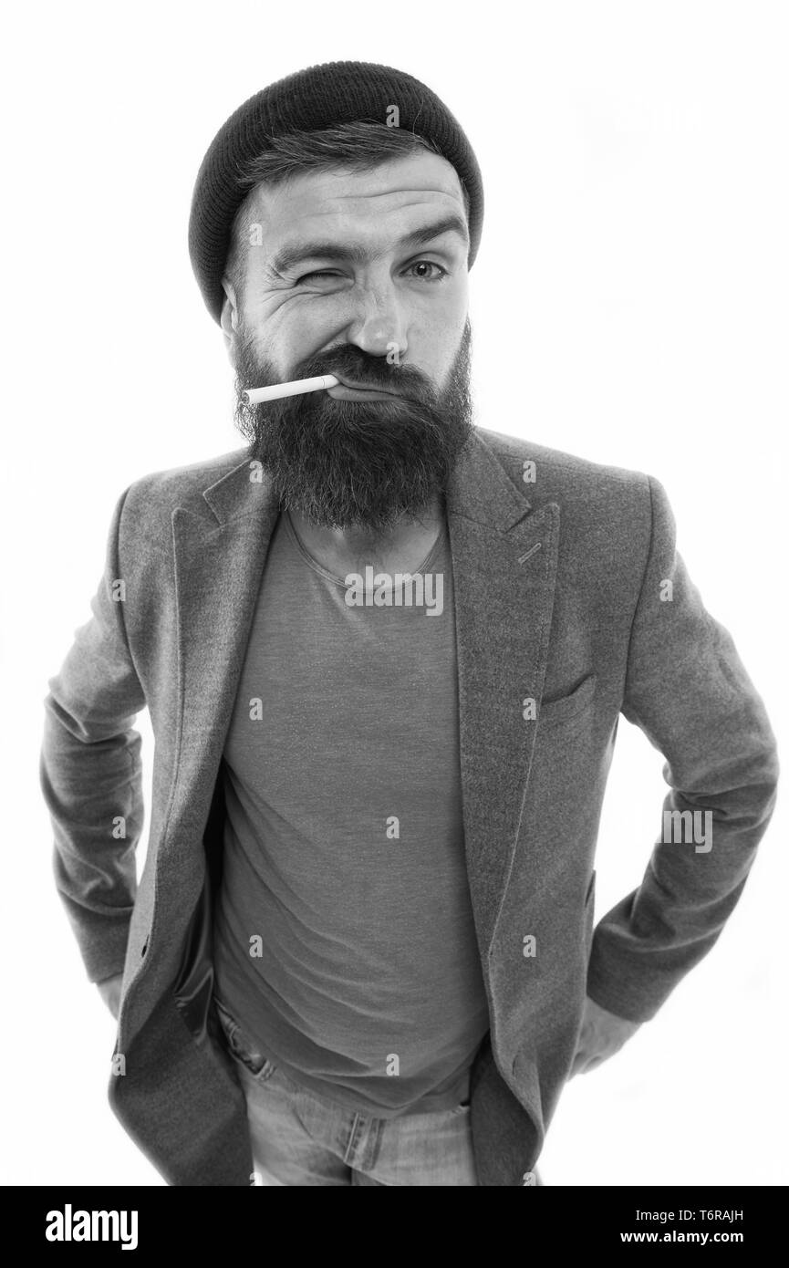 Man brutal bearded hipster dressed as vagabond smoking cigarette ...