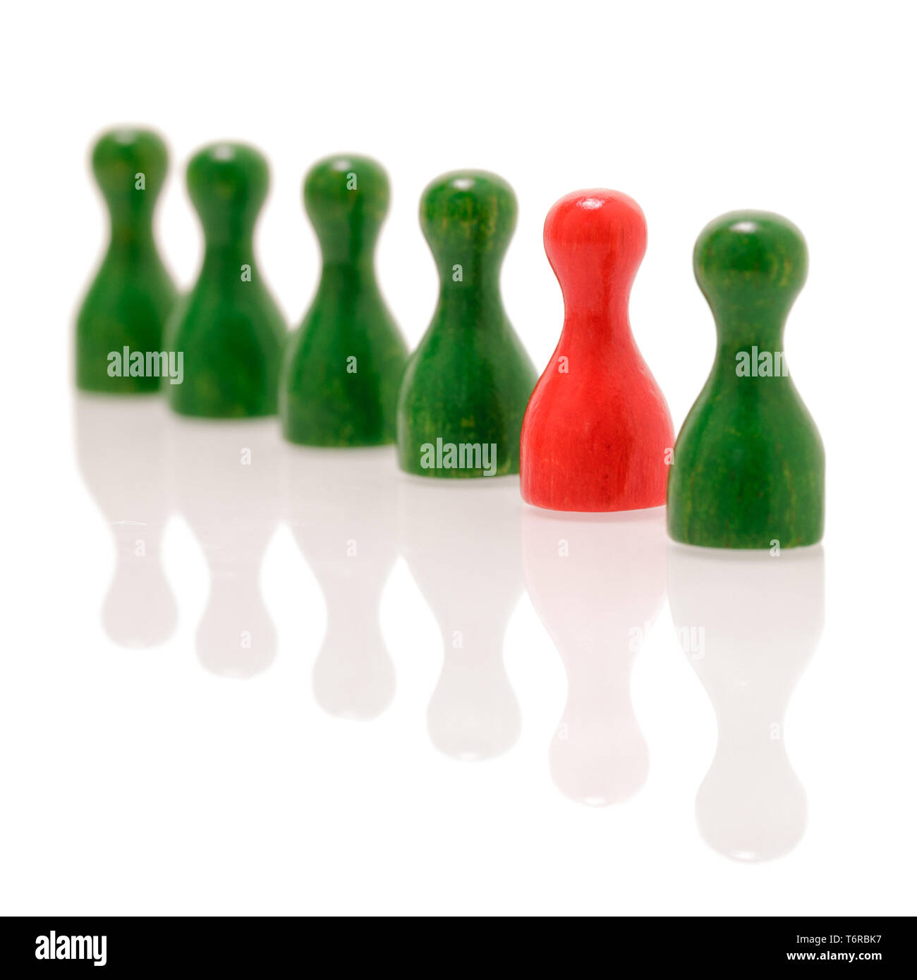 Row of wooden green figures and one red figure. Teamwork, balance and ...