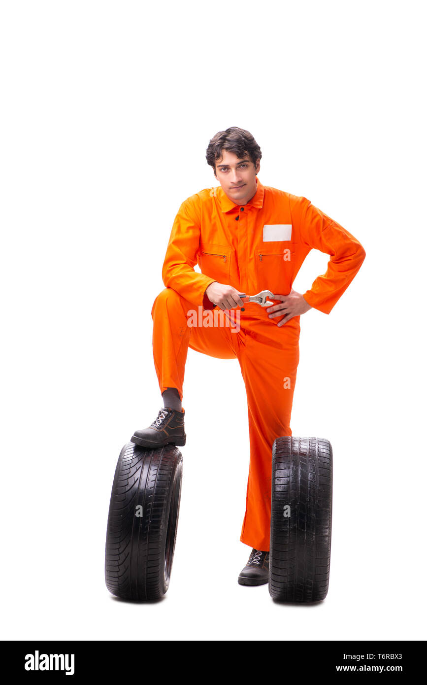 Young garage worker with tyre isolated on white Stock Photo - Alamy