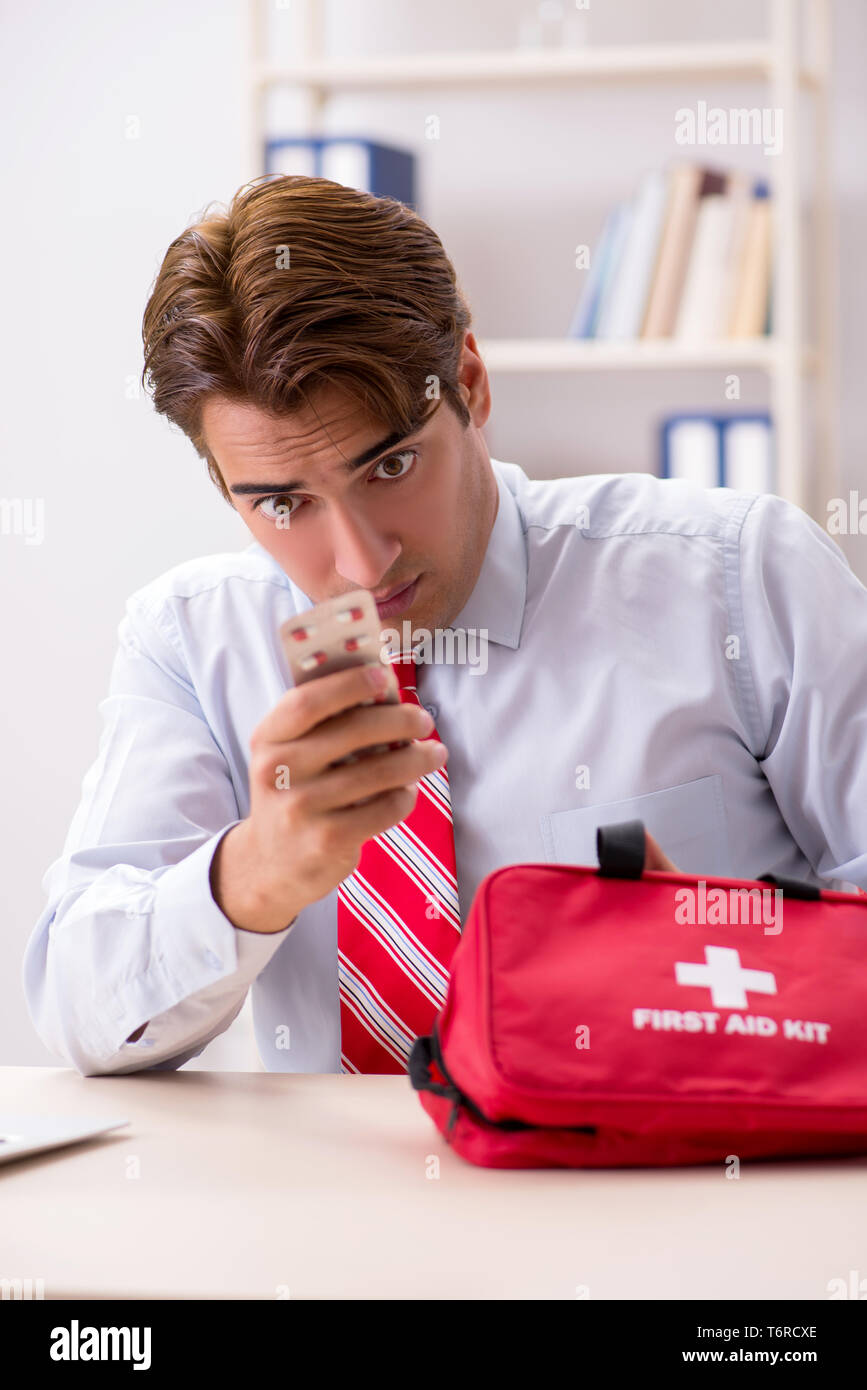 Man with first aid kit in the office Stock Photo - Alamy