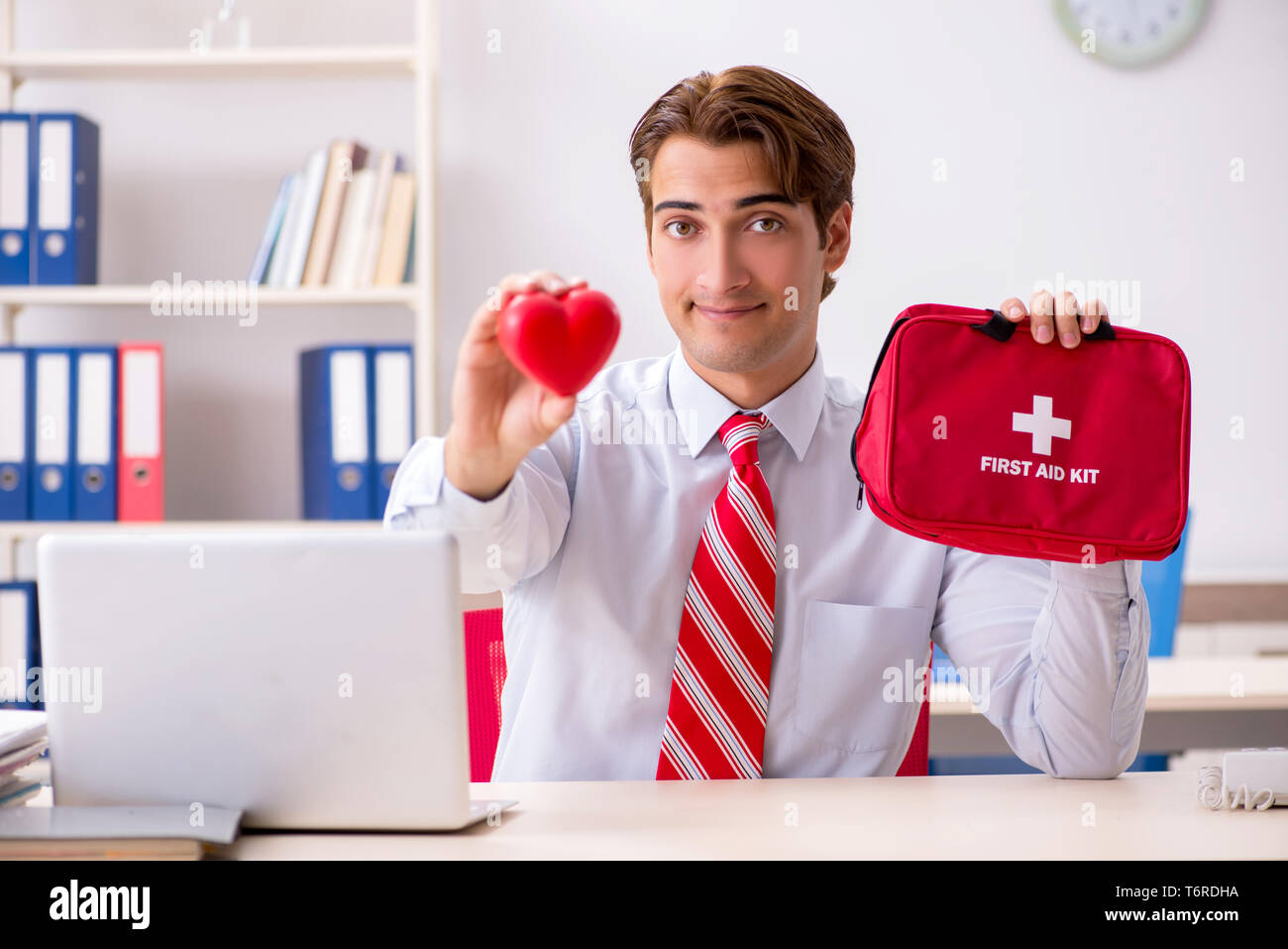 Man with first aid kit in the office Stock Photo - Alamy