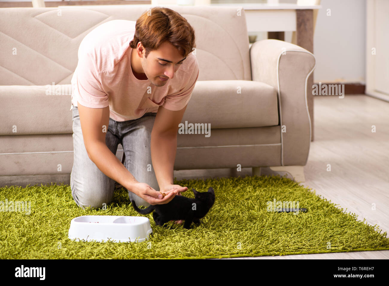 Handsome man playing black cat hi-res stock photography and images - Alamy