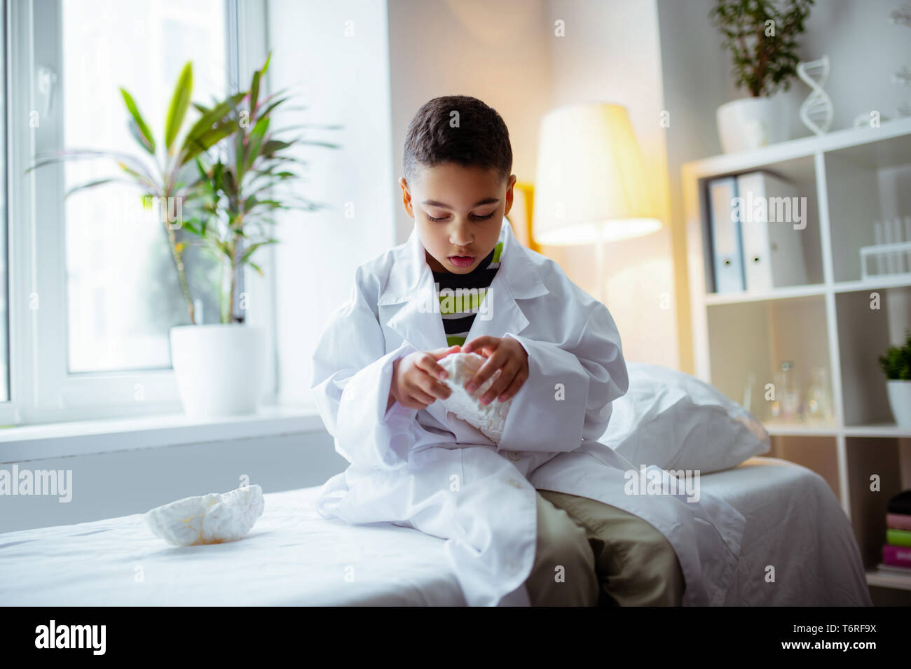 Boy feeling curious playing with model of brain in father office Stock ...