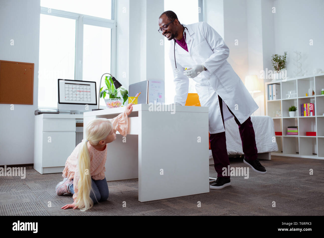 Daughter giving his father pen after picking it up from the floor Stock ...