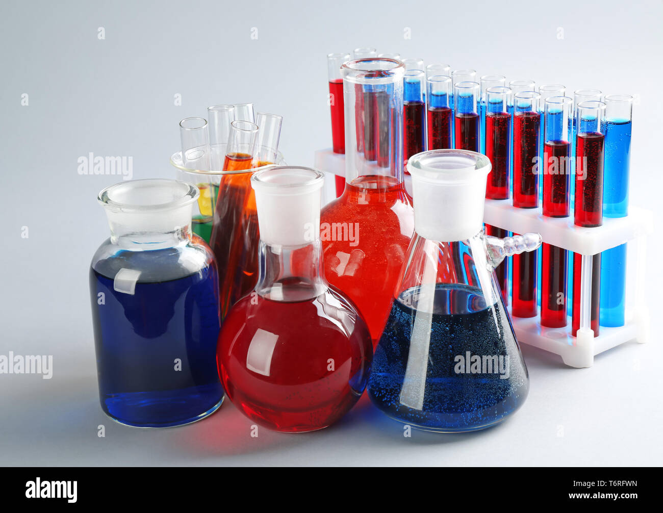 Chemical glassware with colorful liquids on light background Stock ...