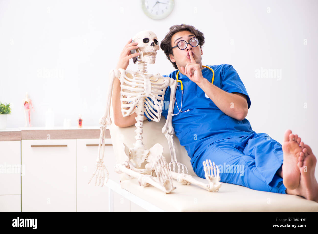 Funny doctor with skeleton in hospital Stock Photo - Alamy