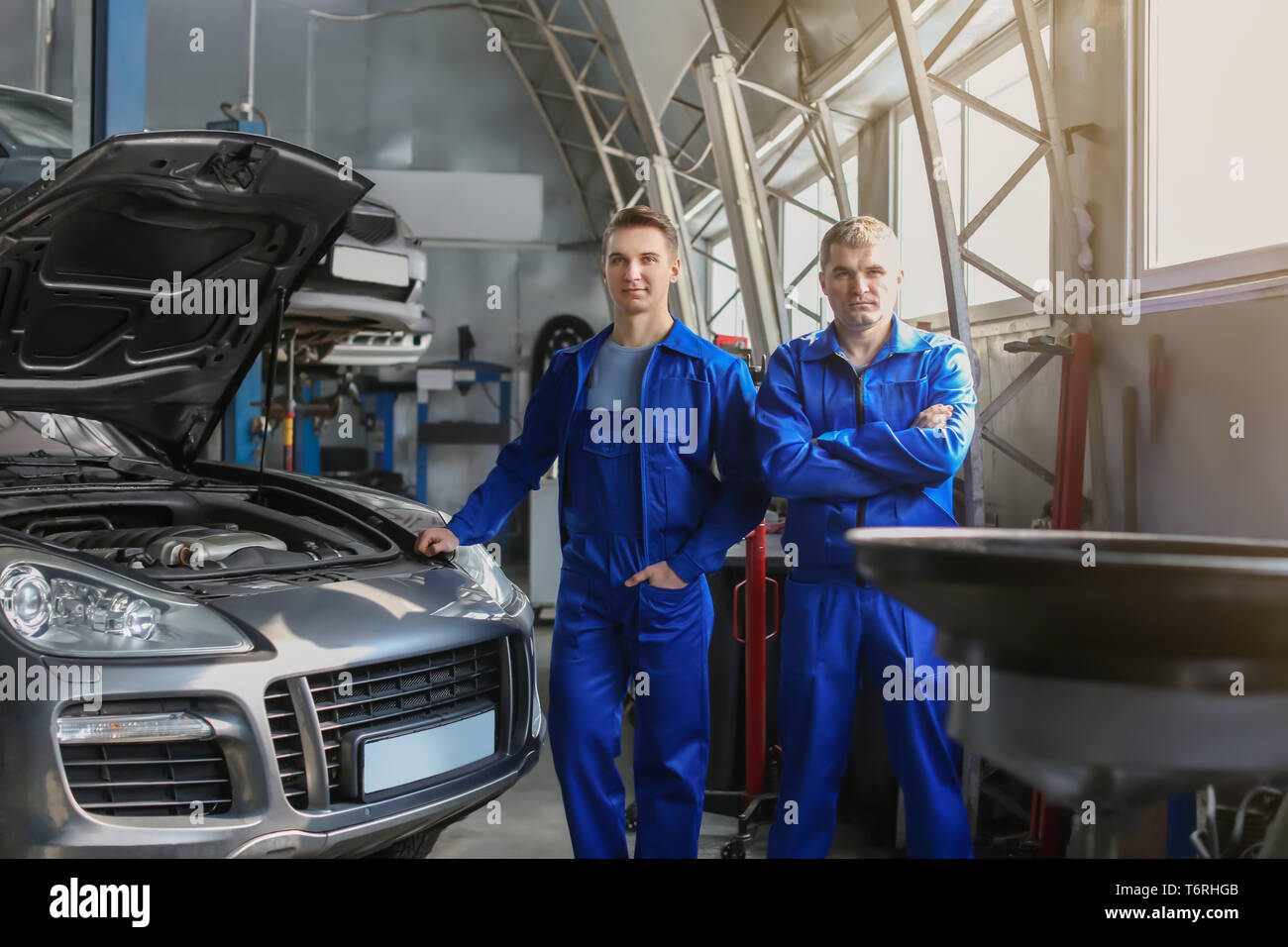 Portrait of male mechanics near car in service center Stock Photo - Alamy