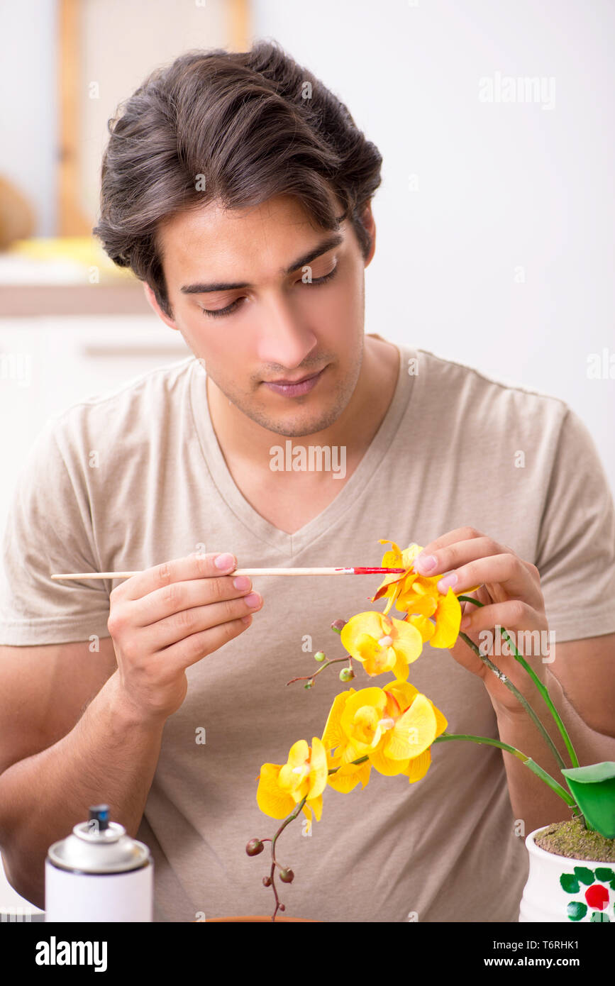 Young man decorating pottery in class Stock Photo - Alamy