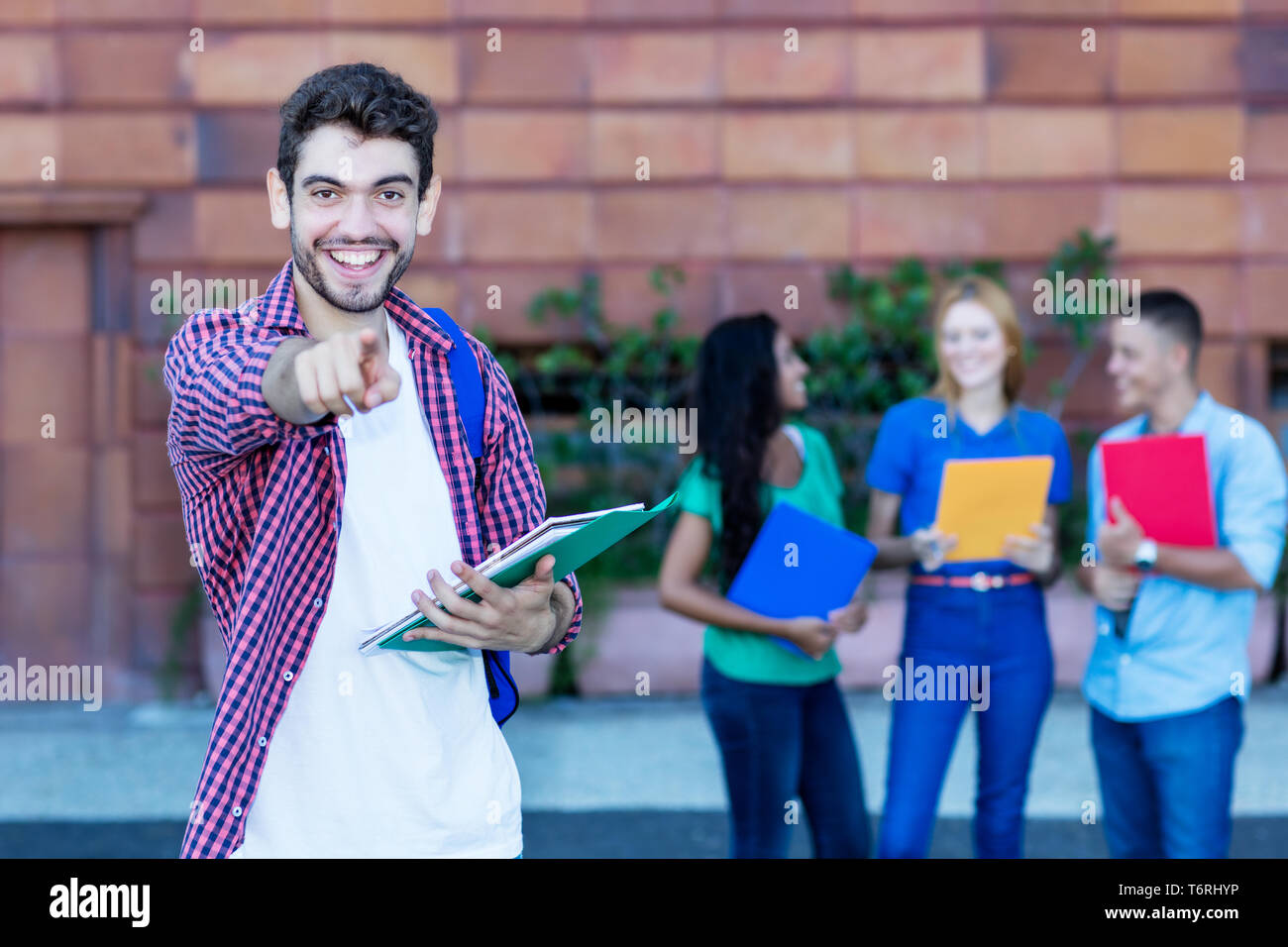 Handsome spanish male student with group of students outdoor in the ...