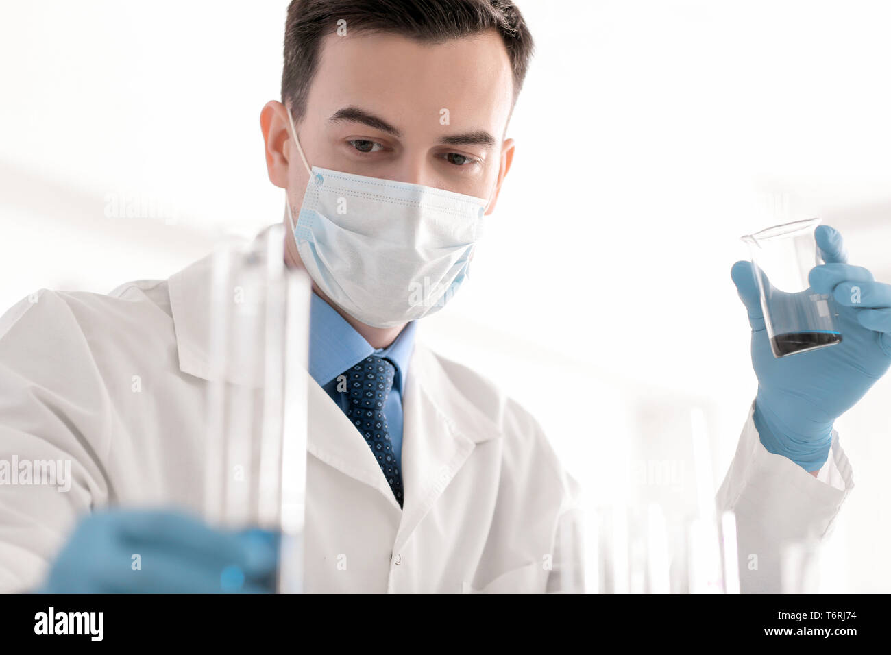 Scientist holding glass beaker with sample in laboratory Stock Photo ...