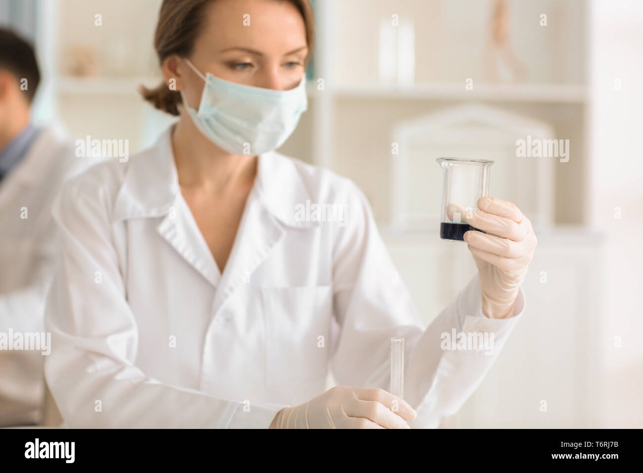 Scientist Holding Glass Beaker With Sample In Laboratory Stock Photo Scientist Holding Glass Beaker With Sample In Laboratory Stock Photo