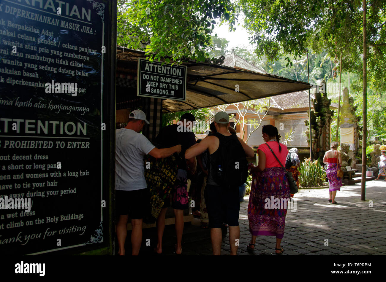 Group of tourists getting the compulsory sarongs before entering Pura ...