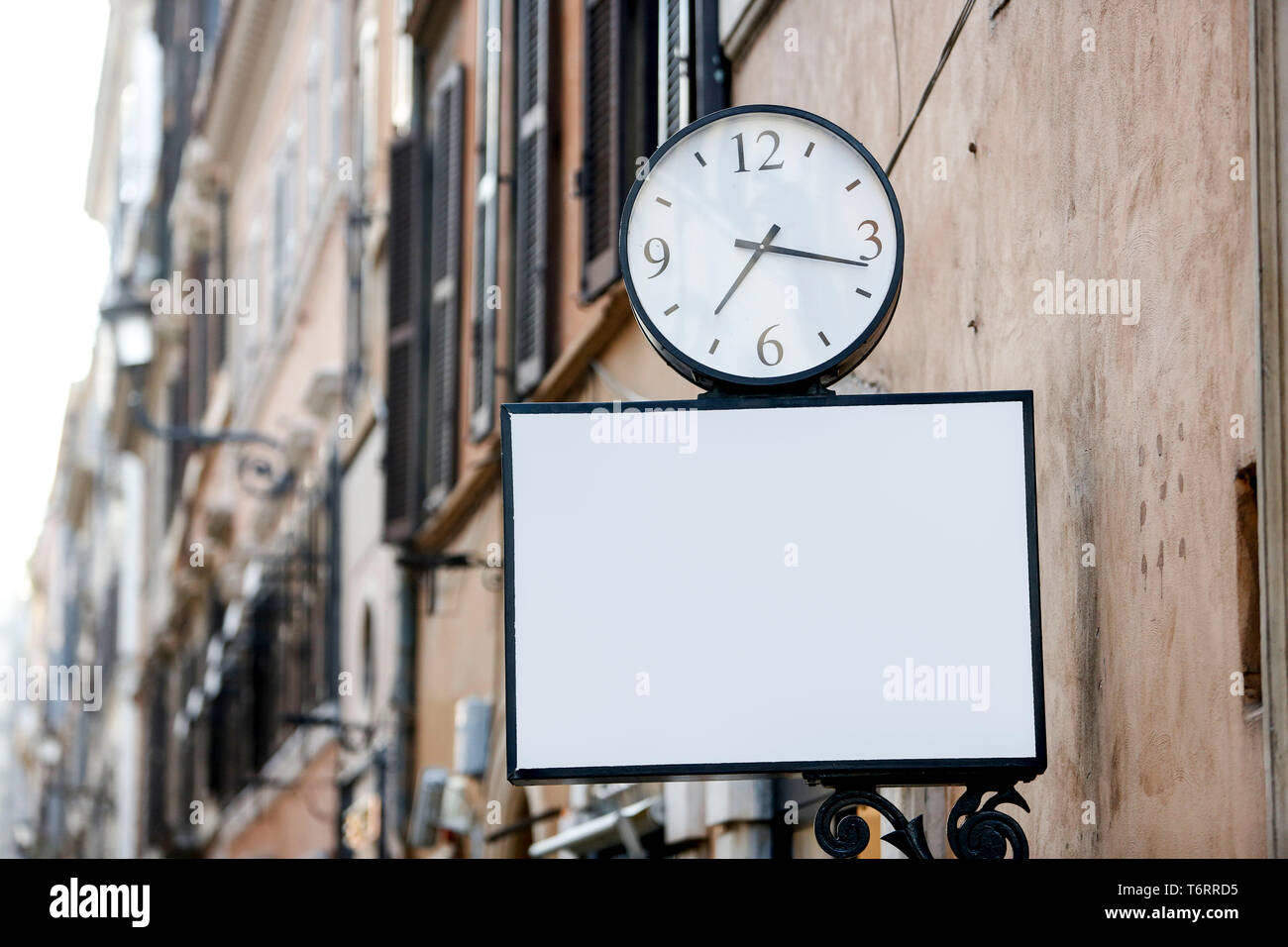Street clock and empty rectangular blank sign on the street in the city ...