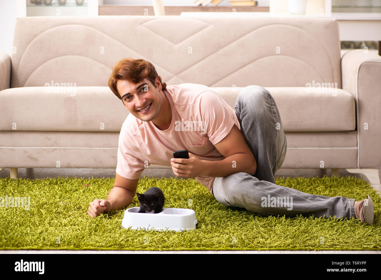 Handsome man playing black cat hi-res stock photography and images - Alamy