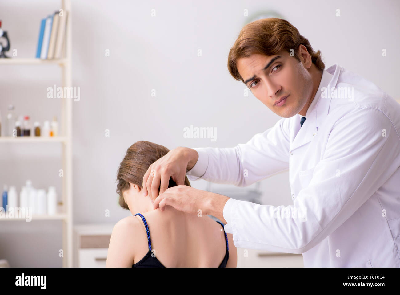 Female patient visiting young handsome doctor chiropractor Stock Photo ...
