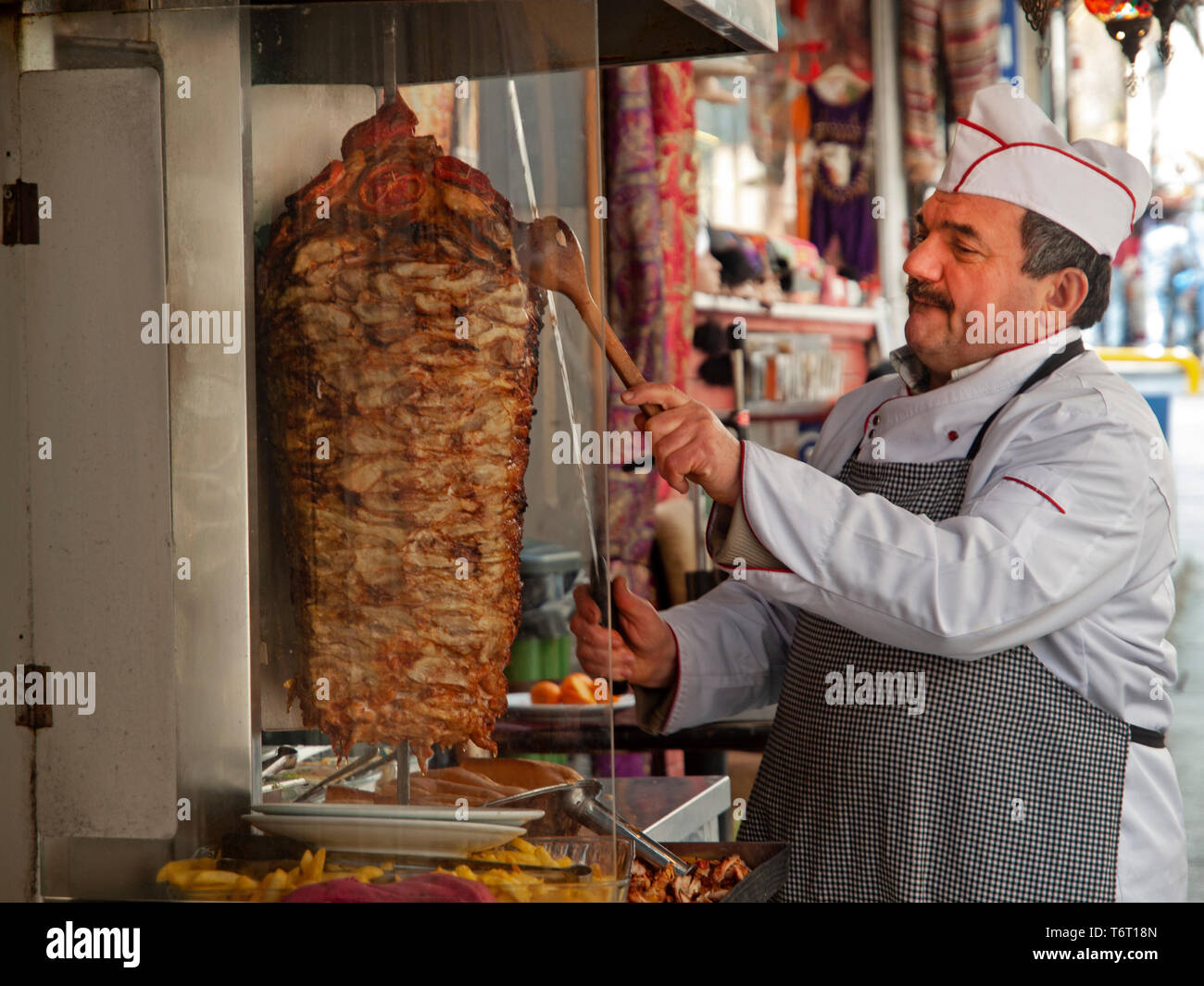 A chef slices doner meat from a rotating spit in Istanbul Stock Photo ...
