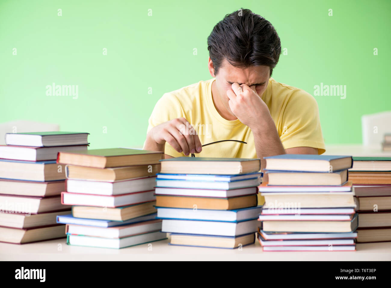 Student with too many books to read before exam Stock Photo - Alamy