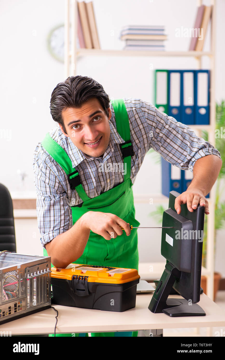 Young engineer repairing broken computer at the office Stock Photo - Alamy