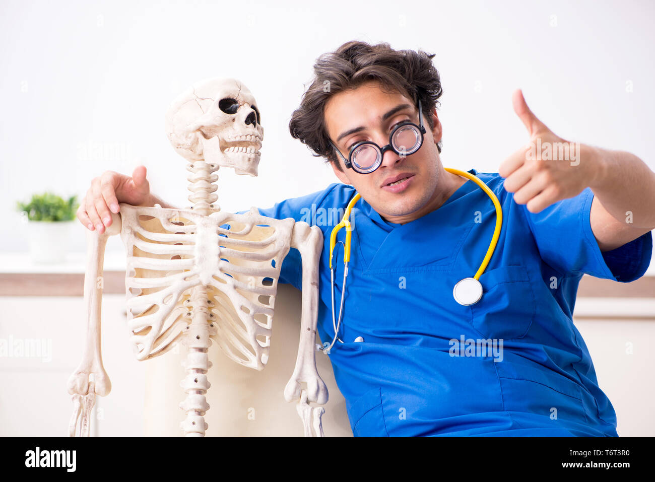 Funny doctor with skeleton in hospital Stock Photo - Alamy