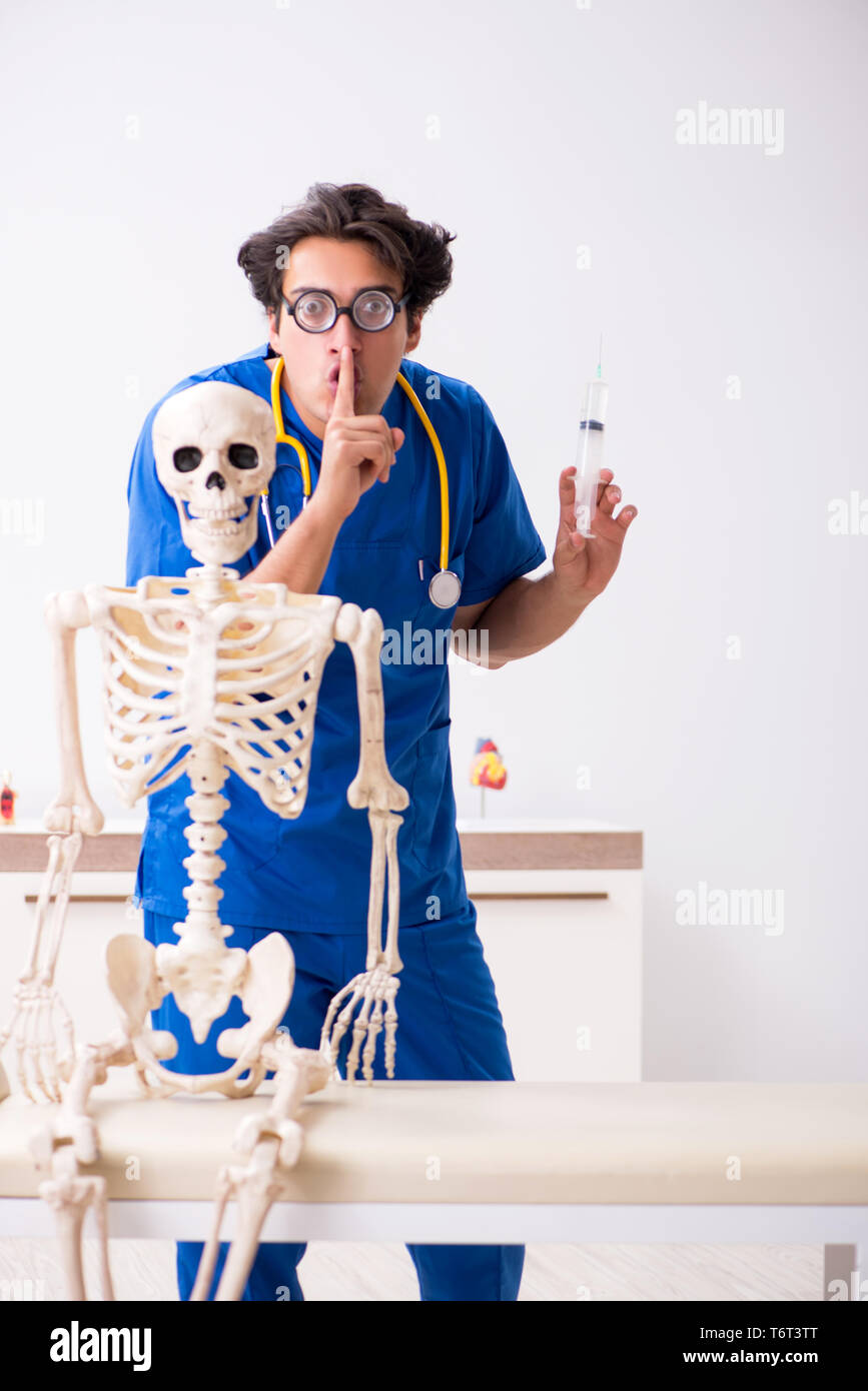 Funny doctor with skeleton in hospital Stock Photo - Alamy