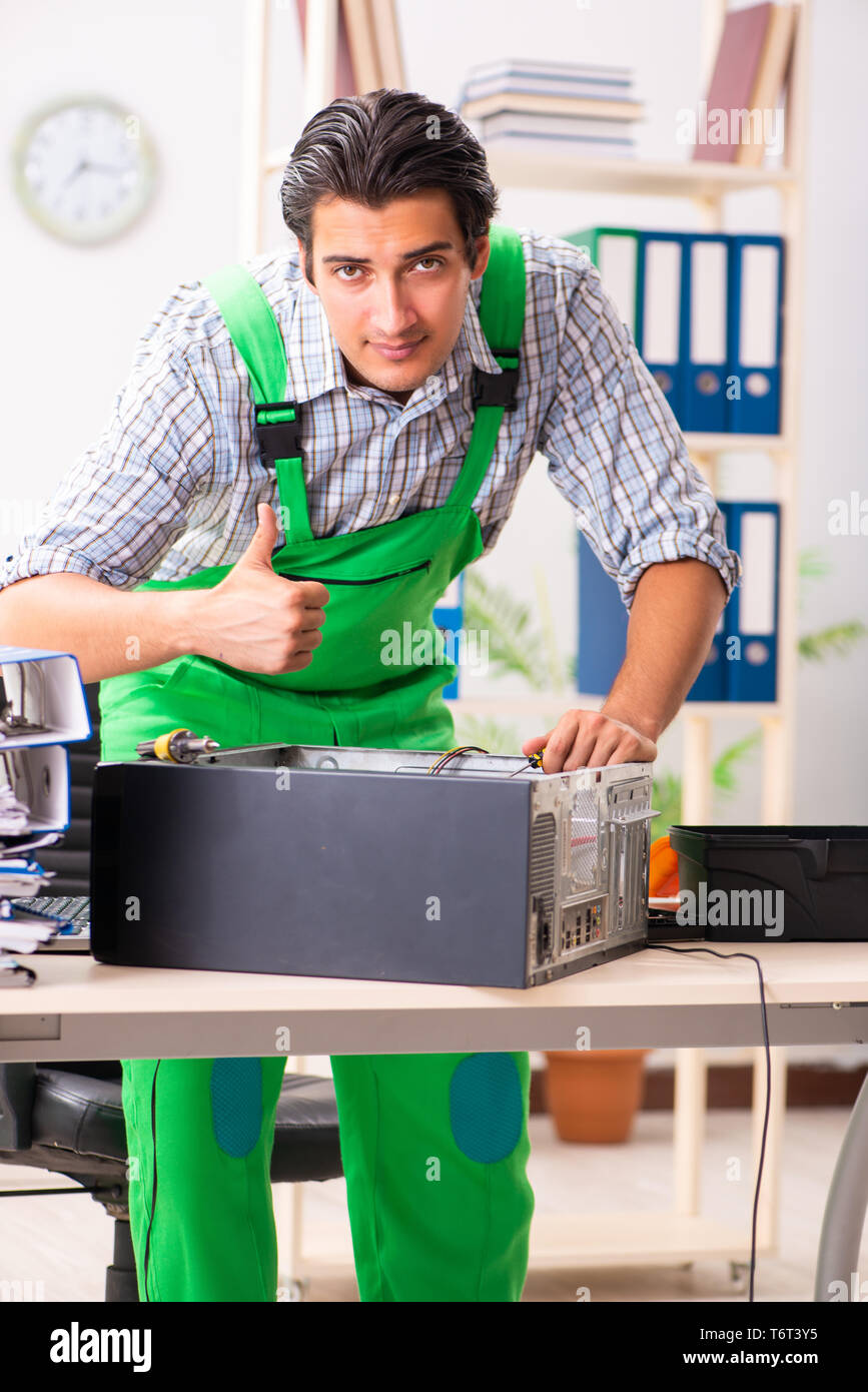 Young engineer repairing broken computer at the office Stock Photo - Alamy
