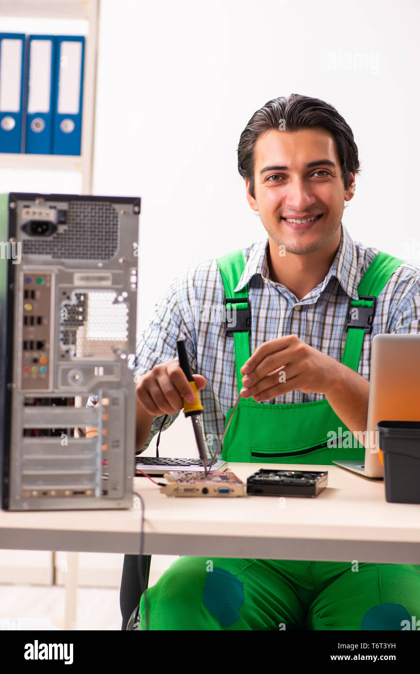 Young engineer repairing broken computer at the office Stock Photo - Alamy