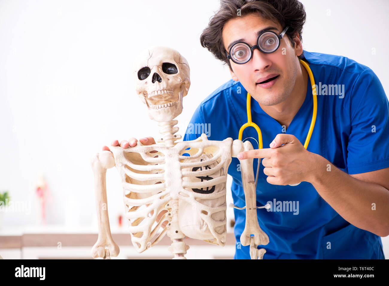 Funny doctor with skeleton in hospital Stock Photo - Alamy