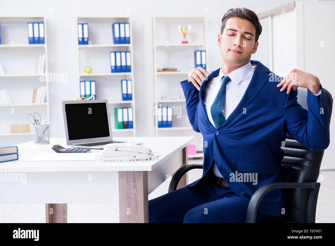 Young businessman doing sports stretching at workplace Stock Photo - Alamy