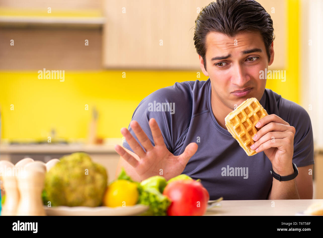 Man having hard choice between healthy and unhealthy food Stock Photo ...