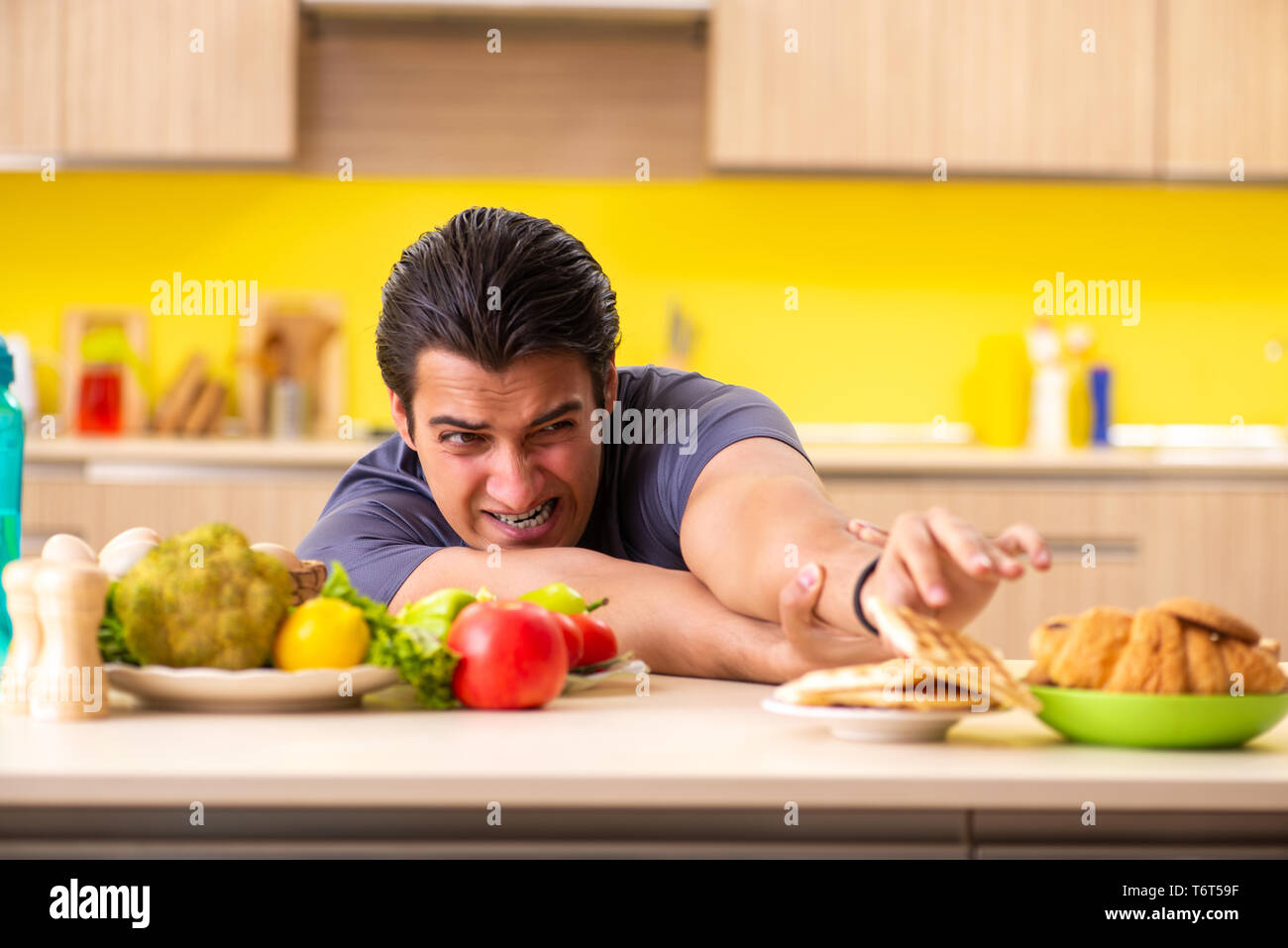 Man having hard choice between healthy and unhealthy food Stock Photo ...