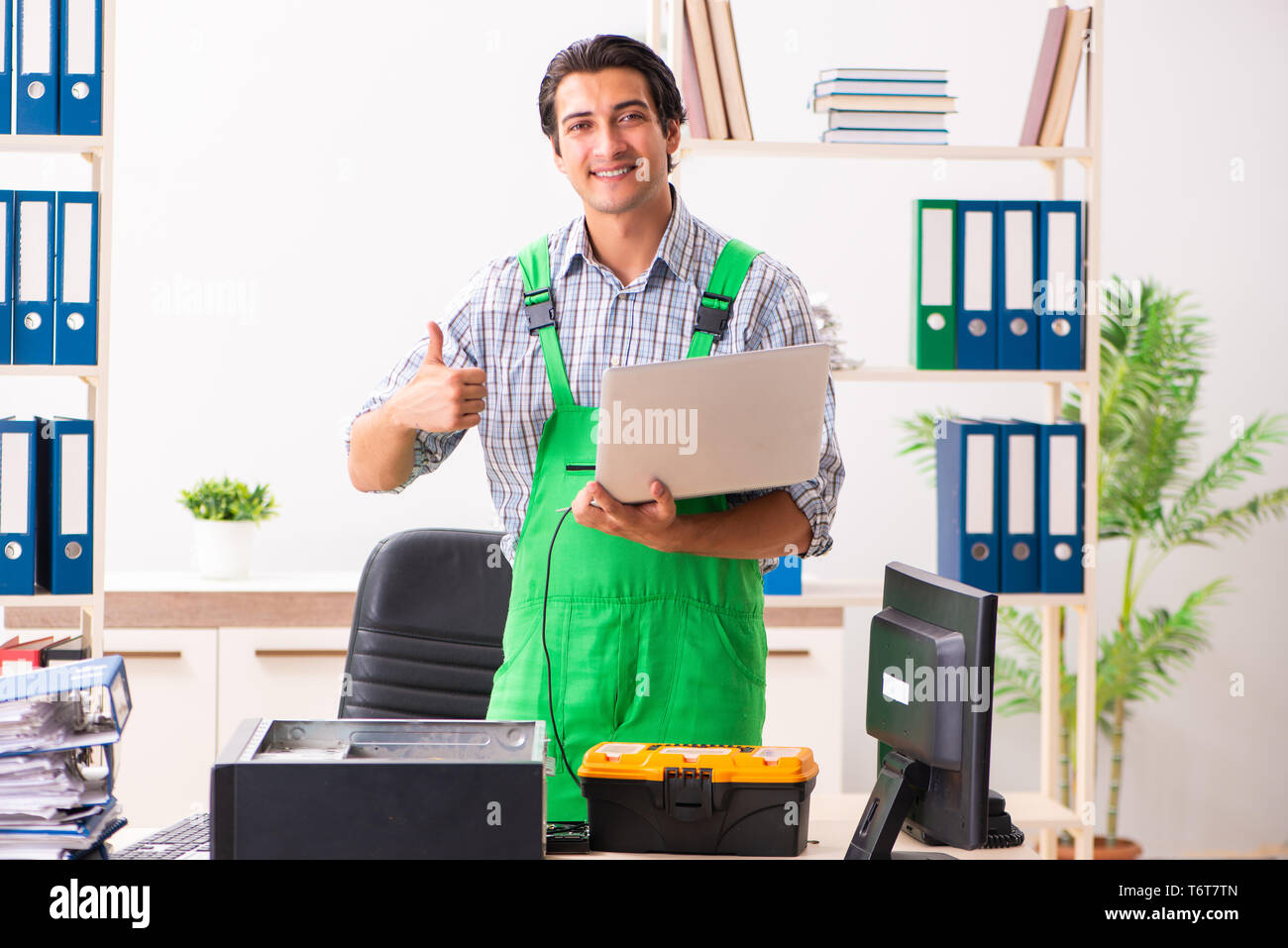 Young engineer repairing broken computer at the office Stock Photo - Alamy