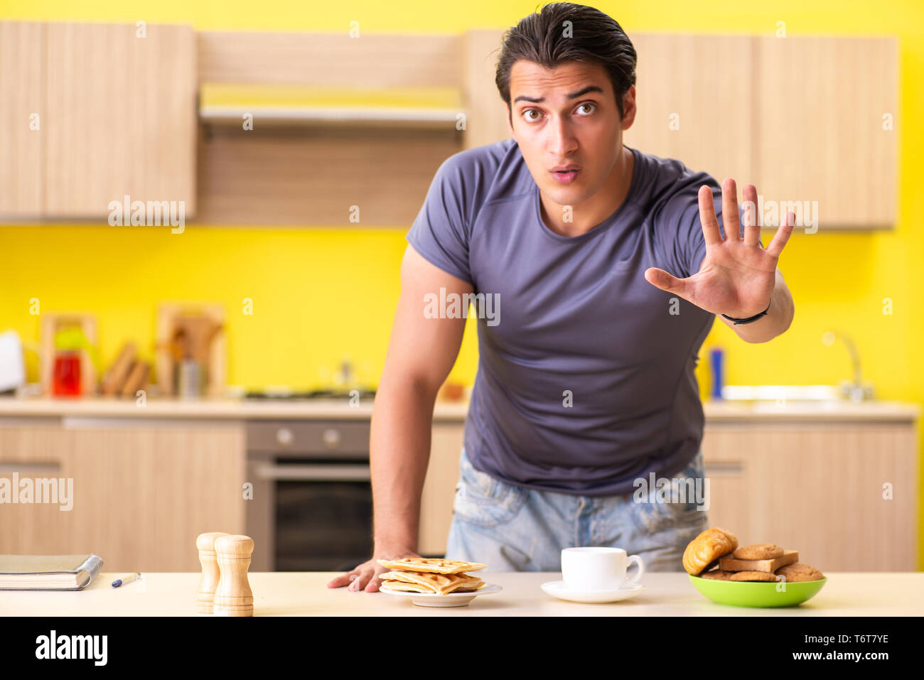 Young man in unhealthy food concept Stock Photo - Alamy